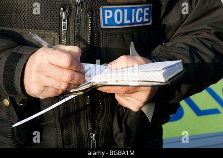 British Police officer writing notes in his pocket book wearing a Stock ...