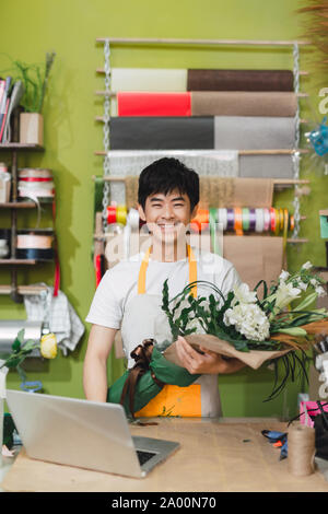 Young hispanic man florist make bouquet of flowers at flower shop Stock ...