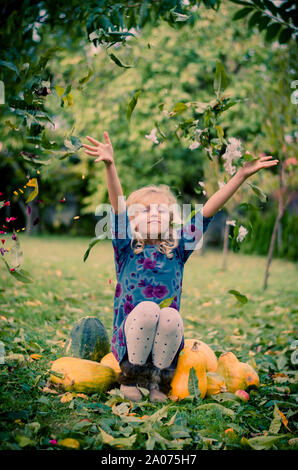 lovely little girl rising up barbell with two hands in pink studio ...