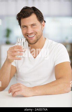 hand holds clear water in glass . hand holding A clear glass of clean ...