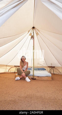 Cozy glamping interior with a woman resting on a couch, combining ...