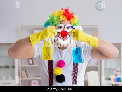 The funny clown doing cleaning at home Stock Photo - Alamy