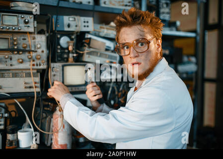 Strange engineer holds electric tube in laboratory. Electrical testing ...