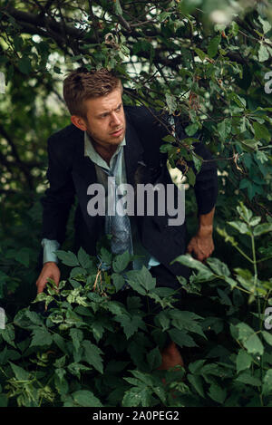 Alone businessman in torn suit walking on desert island. Business risk ...