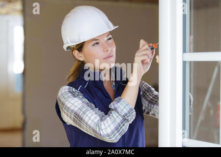 female window fitter using screwdriver Stock Photo - Alamy