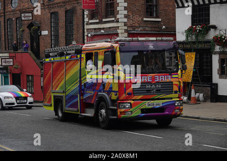 Fire engine painted with Pride rainbow colours, with words Fire doesn't ...