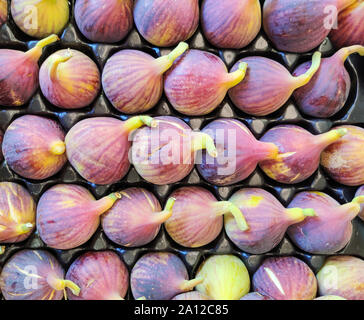 Top view of a group of green figs on a white table and metallic knife ...