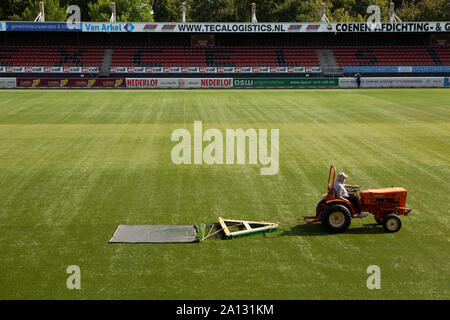 Maintenance worker on a tractor making a pristine soccer field of the ...