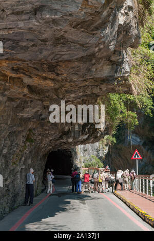 A group of photographers trying to take shot of cliffside tunnel on ...