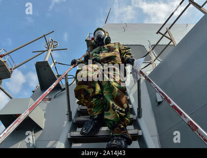 US Navy Damage Controlman during a General Quarters (GQ) drill, checks ...