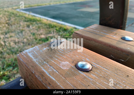 Close-up of wooden boards fastened with metal nails on a bench outdoors ...