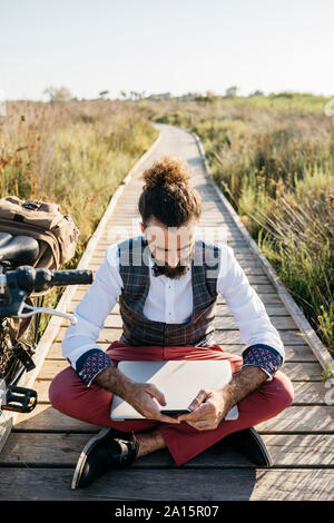 Man with laptop in front of wooden house Stock Photo - Alamy