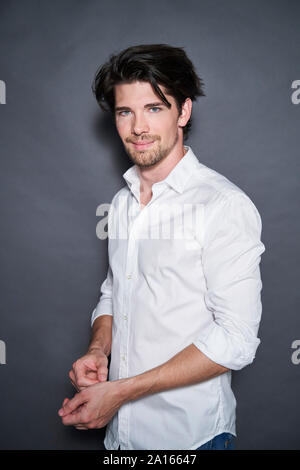 Handsome man wearing white shirt and jeans, windy day in harbour Stock ...