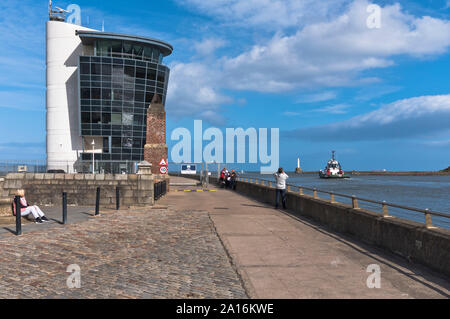 Harbour master's control tower at the entrance to port with beach on ...