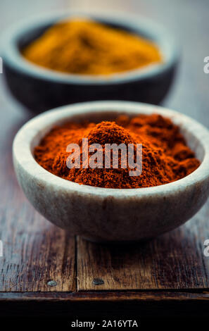 Powdered paprika in small wooden bowl isolated on white Stock Photo - Alamy