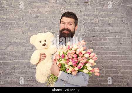Happy bearded man give flowers and gift to woman. Love, relationship ...