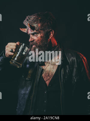 Halloween man demon drink beer on black background Stock Photo - Alamy