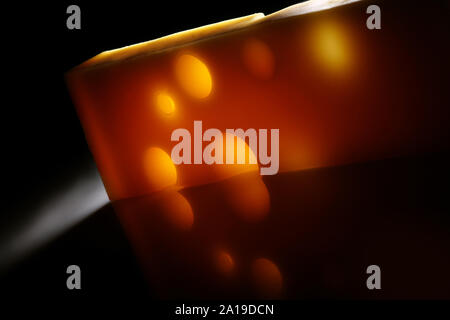 Swiss cheese, emmenthaler, with holes in. Low key photograph Stock ...
