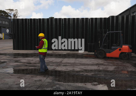 Forklift driver using smartphone outside factory warehouse Stock Photo ...