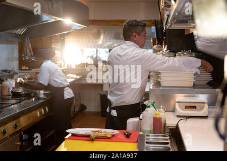 Team of restaurant kitchen staff busy at work Stock Photo - Alamy