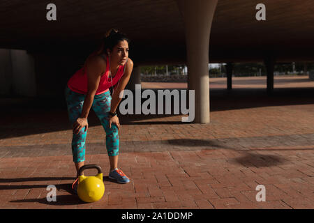 Woman exercising in a park with kettlebell Stock Photo - Alamy