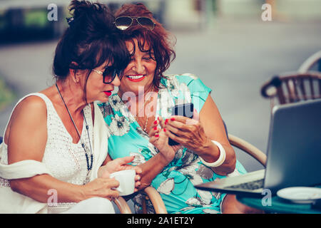 Two elderly women talking gossip Stock Photo - Alamy