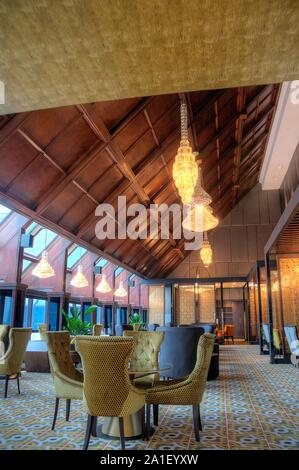 Tables and lounge chairs with hanging lights in a comfortable lounge ...