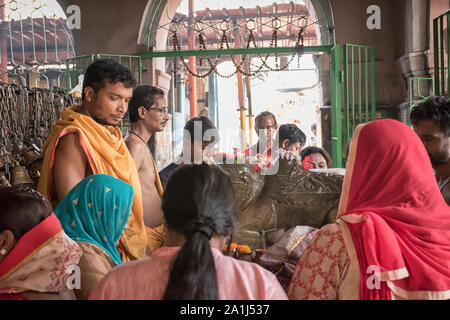 Group of people doing puja to statue of Stones at Baba Taraknath Temple ...
