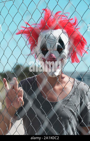 Scary horror clown looking through window Stock Photo - Alamy