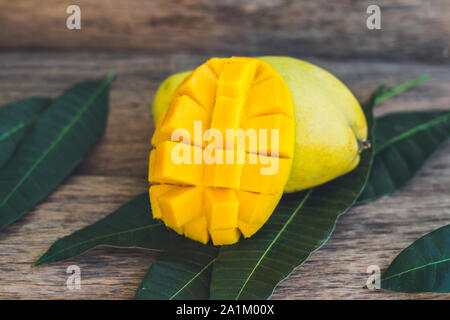 Mango and mango leaves on an old wooden background Stock Photo - Alamy