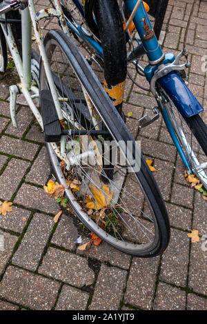 2 damaged bikes with broken wheels chained up Stock Photo - Alamy