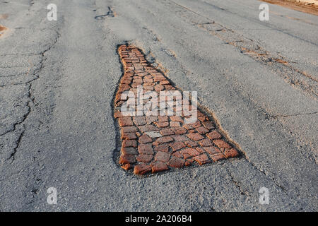 potholes in the road sealed with old bricks. Creative way to repair ...