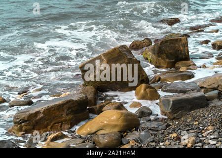 Vet sea rocks in the beach in seashore Stock Photo - Alamy