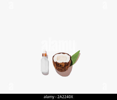 Cracked coconut and bottle of essential oil on beige background Stock ...