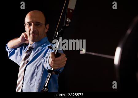 Businessman shooting bow and arrow on white background Stock Photo - Alamy