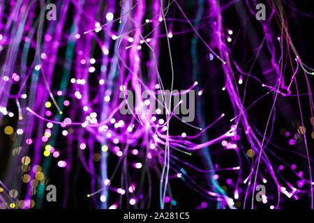 A closeup of small light bulbs hanging in a dark room Stock Photo - Alamy