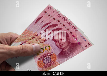 Holding a Chinese 100 RMB banknote in the right side of the picture ...