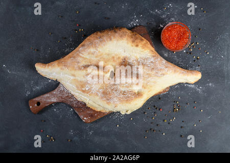 Georgian bread lavash with red caviar on wooden board on dark rustic ...