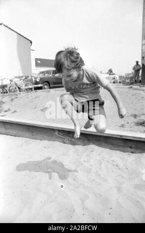 A boy is jumping in a sandbox Stock Photo - Alamy