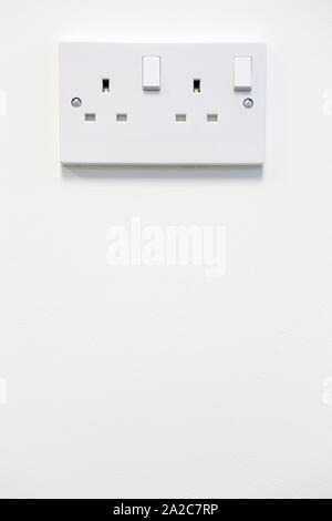 UK domestic 3 pin double plug electrical socket in white plastic on a ...