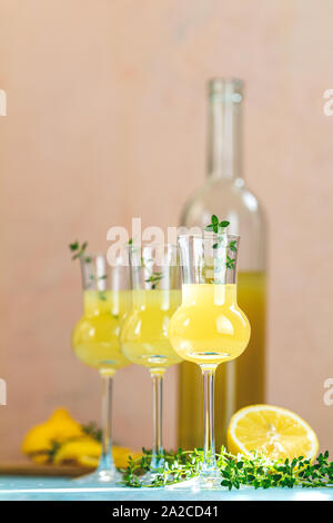 Limoncello with thyme in grappas wineglass with water drops close up on ...