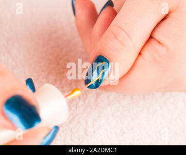 Woman hands use brush to apply blue paint to living plant leaves and ...