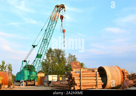 Crane works pipes unloading. Working crane lifts the pipe Stock Photo ...