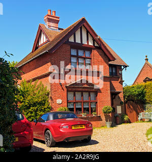 Large detached red brick country house with overhanging porch and ...