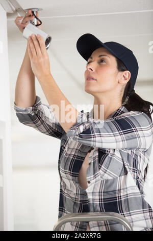 female cctv installer checking security camera Stock Photo - Alamy