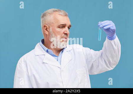 Mature scientist with grey hair and beard in white coat standing Stock ...