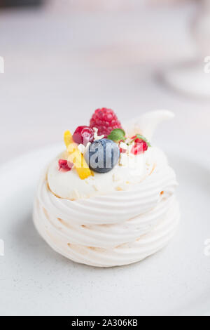 Small Pavlova dessert with raspberry, blueberry, and mint. Top view ...