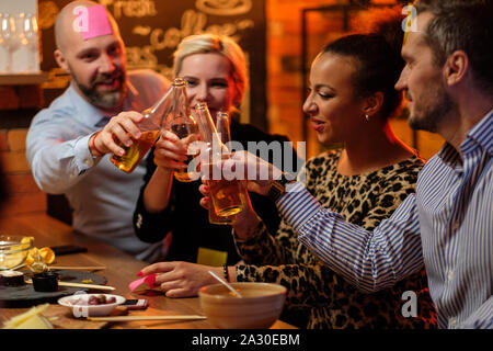 Group of friends playing sticky head game behind bar counter in a cafe ...