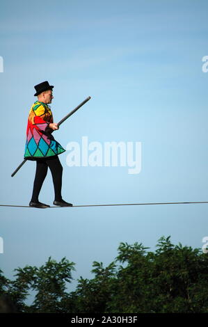Tightrope walker performing stunts, pole for balance Stock Photo - Alamy