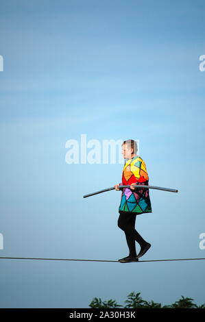 Tightrope walker performing stunts, pole for balance Stock Photo - Alamy